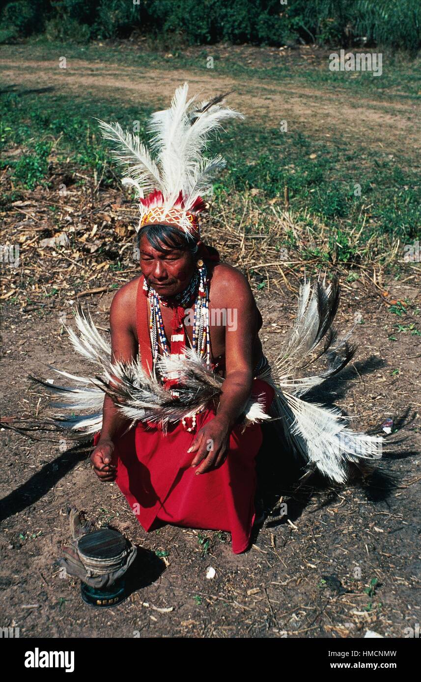 Maka musician wearing traditional clothing and feather headdress ...