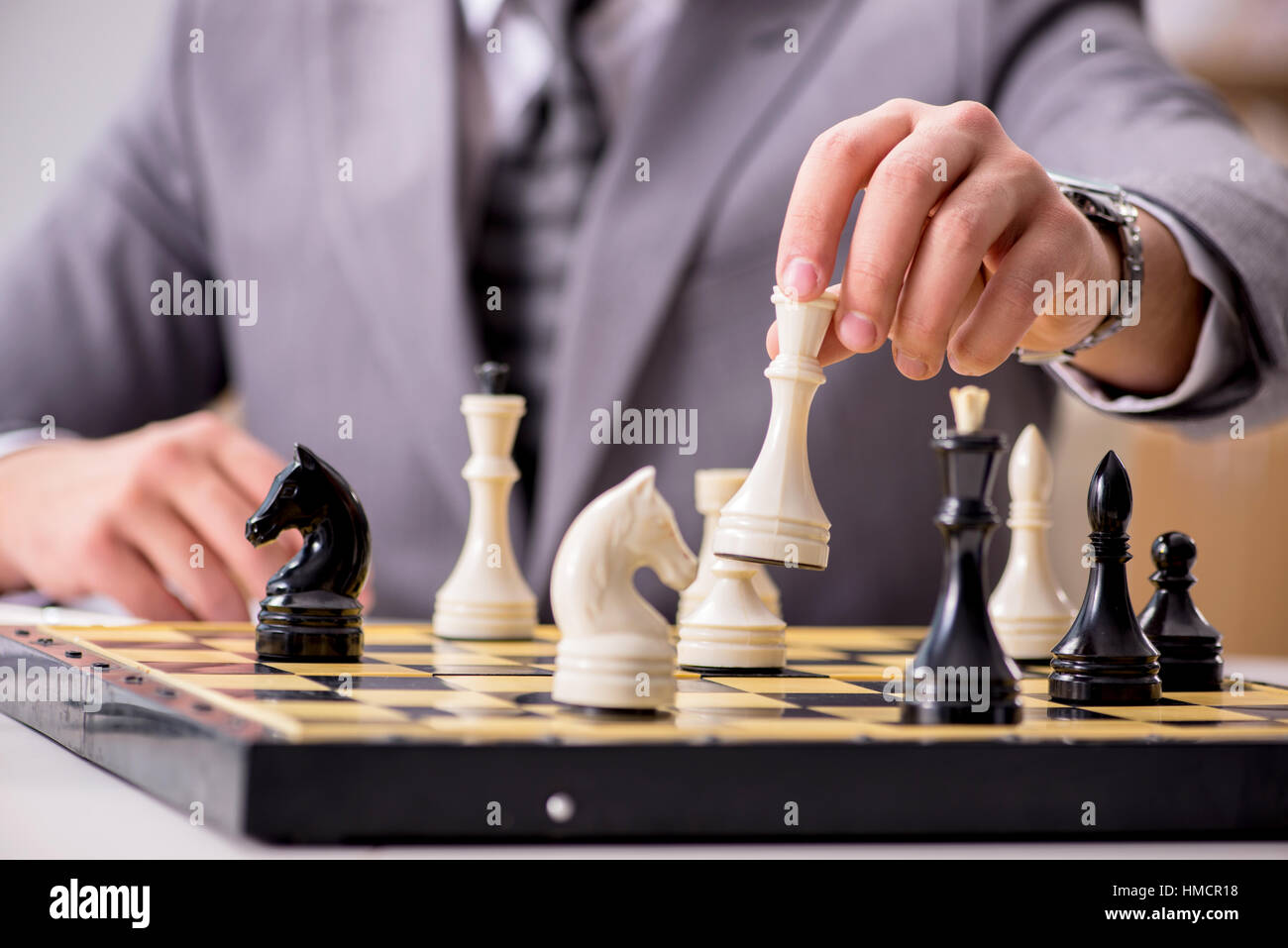 Young businessman playing chess in the office Stock Photo - Alamy