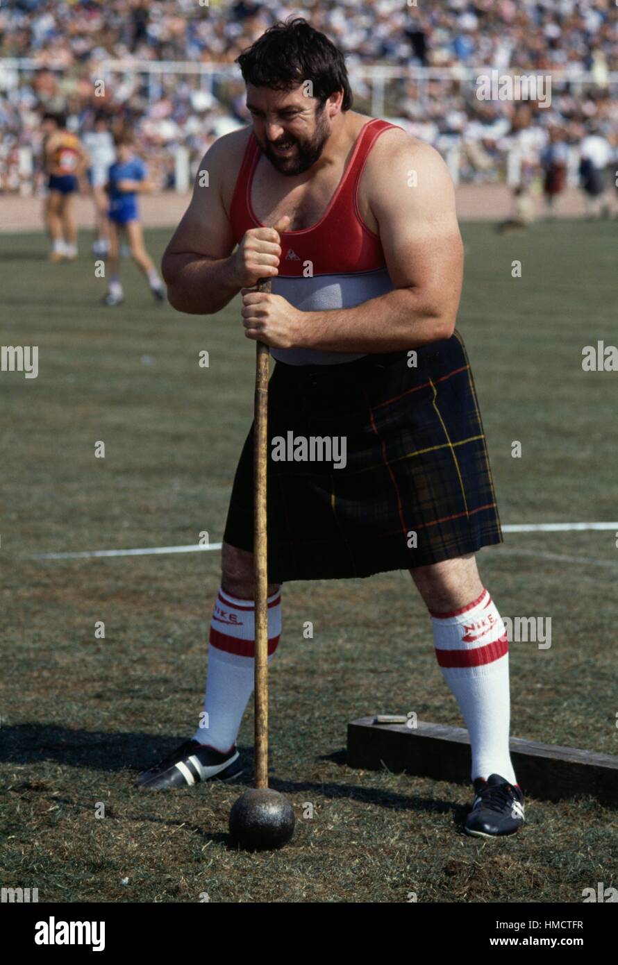 Man wearing traditional clothes preparing to throw the Scottish hammer ...