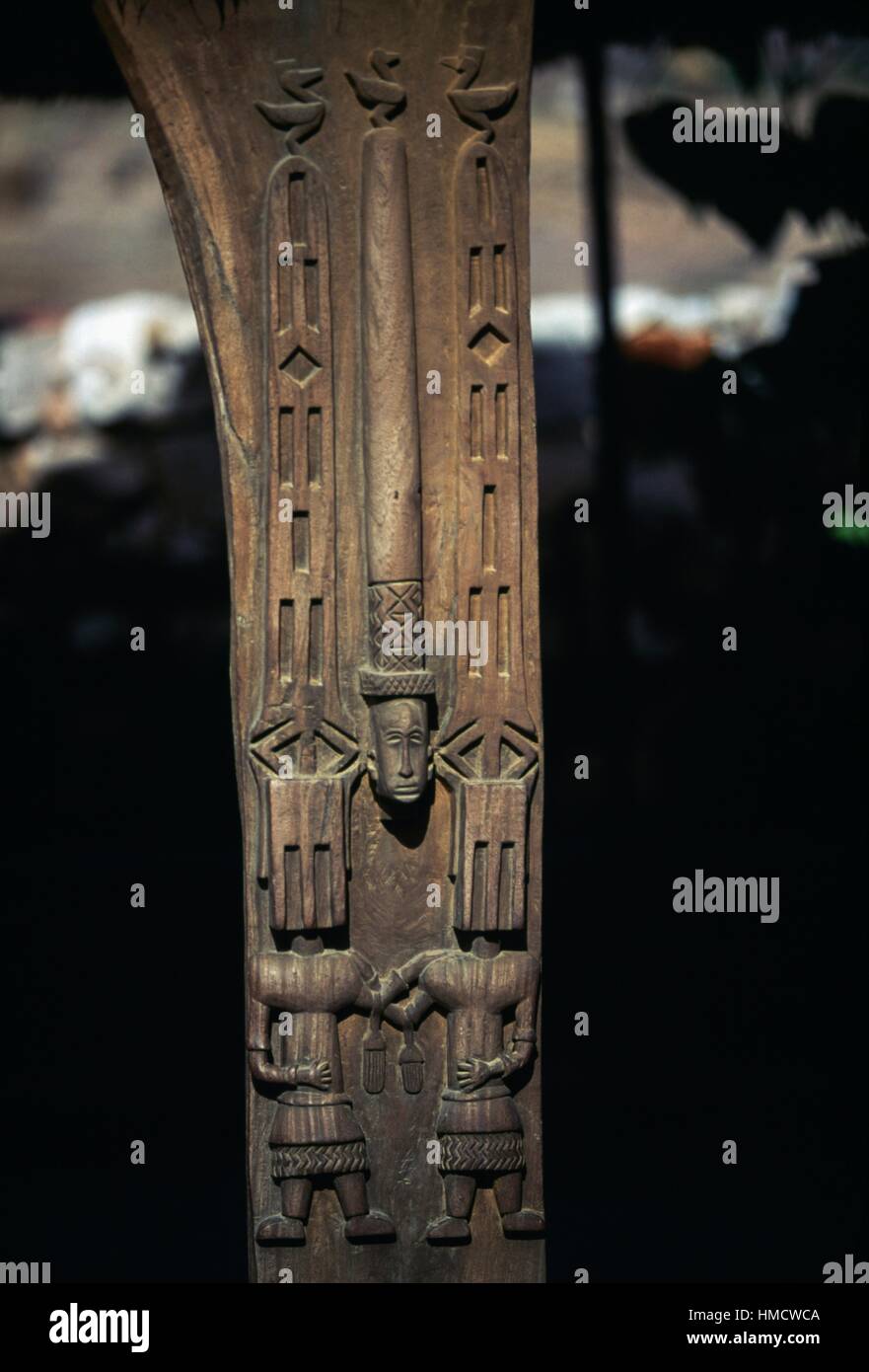Carved wooden pole from a toguna depicting a ritual mask, meeting house ...