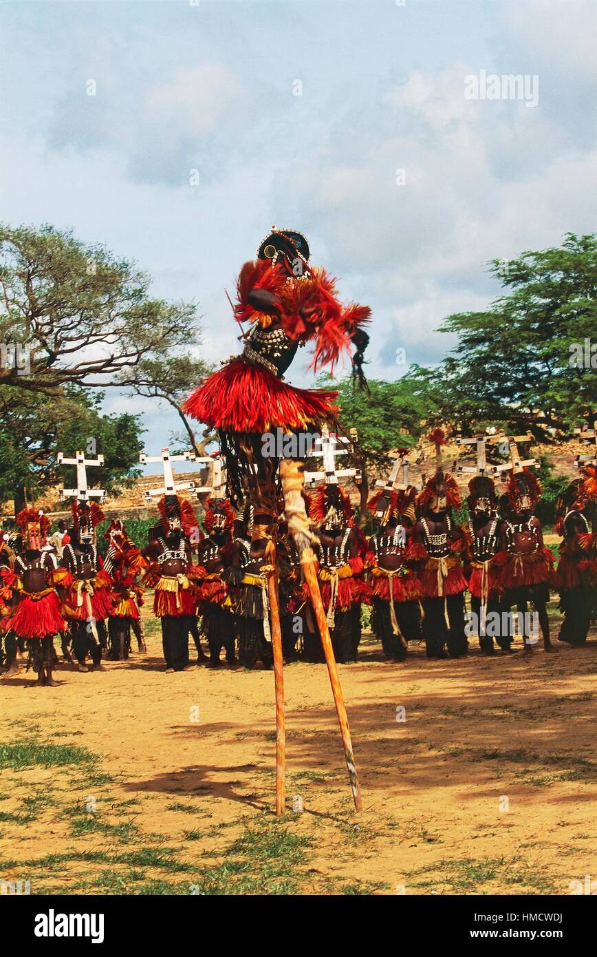Dogon dancers, one of them on stilts, wearing Kanaga masks performing ...