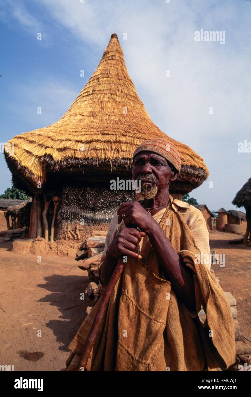 A man in front of a sacred house in the village of Niofouin, Senufo ...