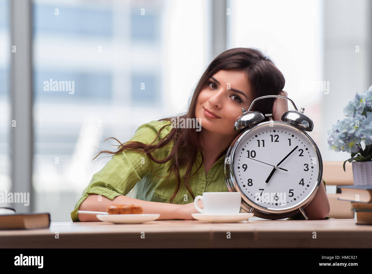 Student with gian alarm clock preparing for exams Stock Photo - Alamy