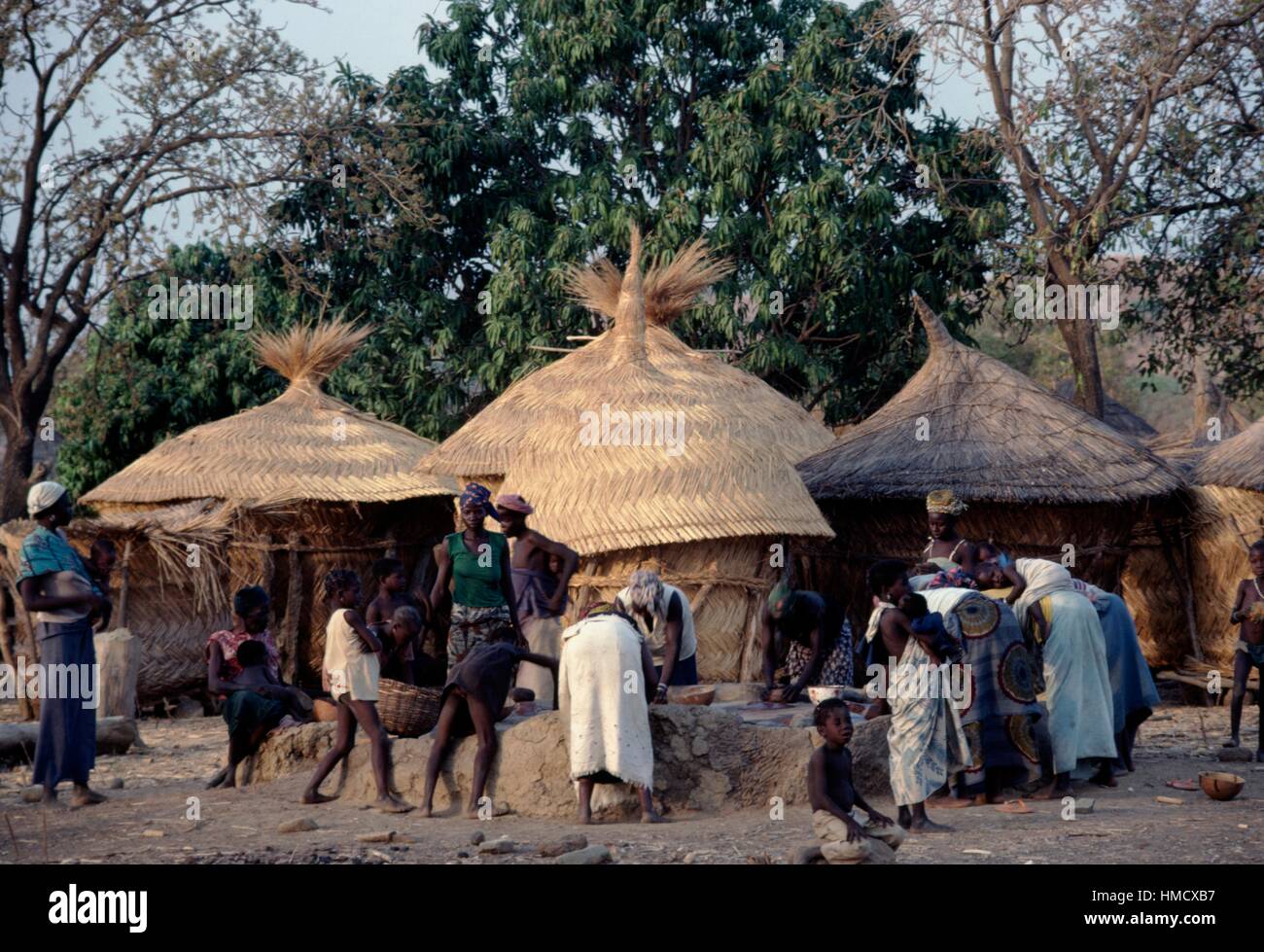 Village with its inhabitants and huts with thatched roofs near Poura ...