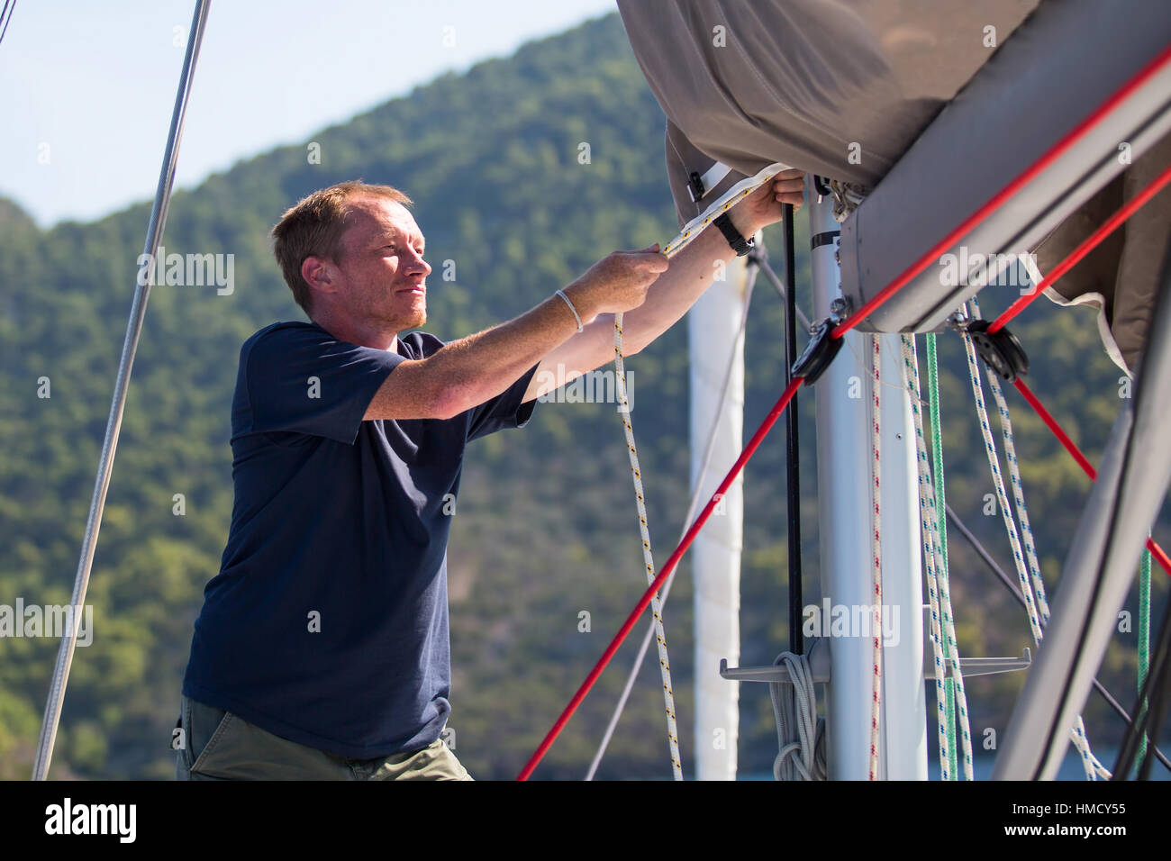 Skipper tightens the ropes on his sailing yacht Stock Photo - Alamy