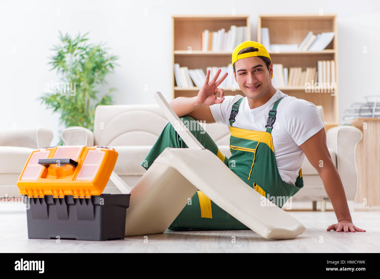 Worker repairing furniture at home Stock Photo - Alamy