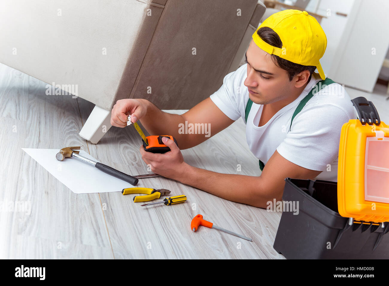 Worker repairing furniture at home Stock Photo - Alamy