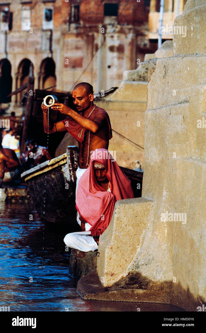 Men wearing traditional clothes making ritual ablutions in the river ...