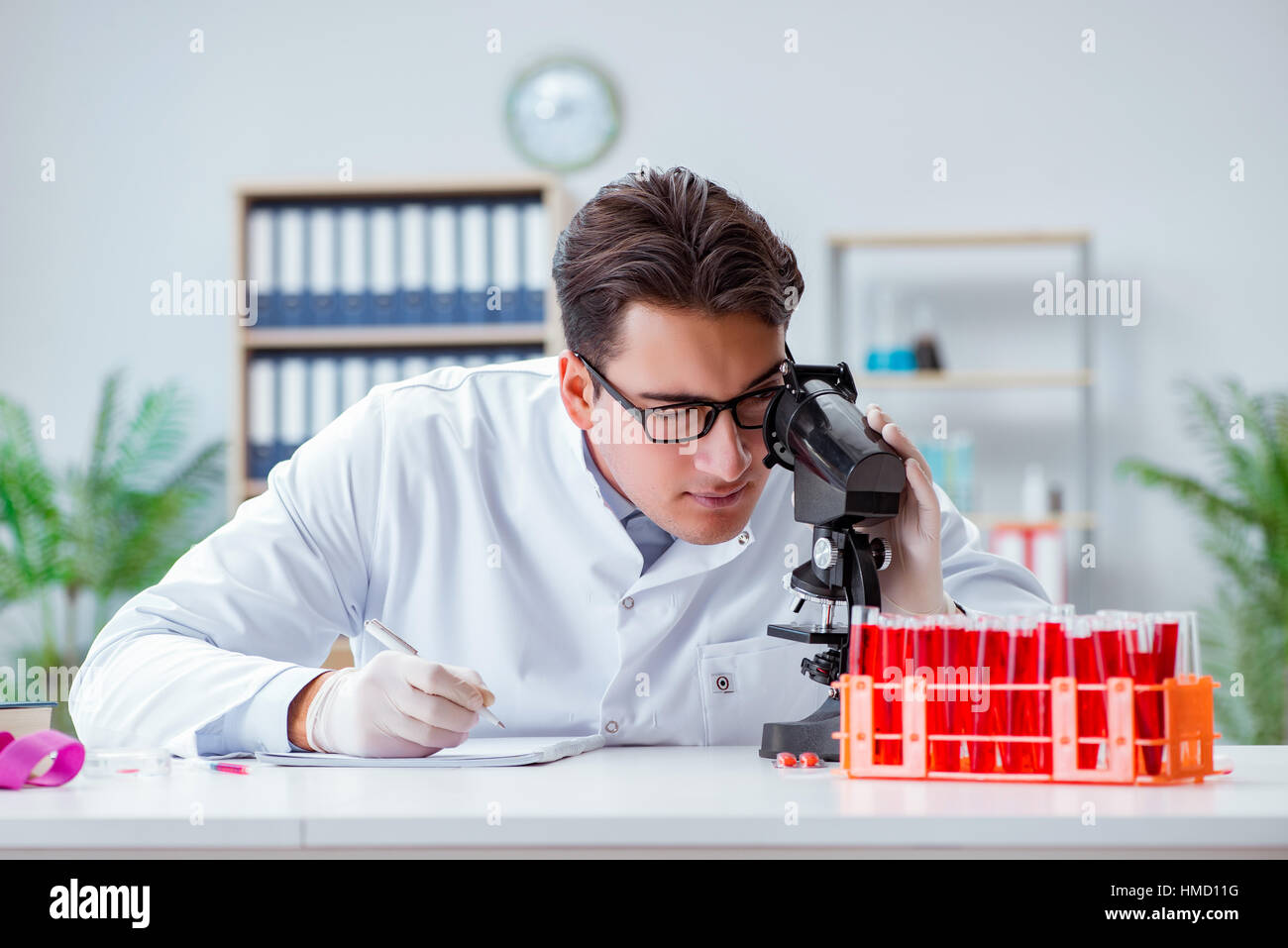 Young doctor working in the lab with microscope Stock Photo - Alamy