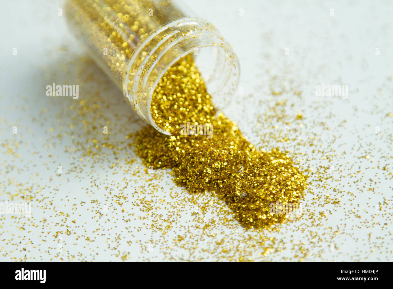 Golden tinsels falling from the tube on white background Stock Photo ...