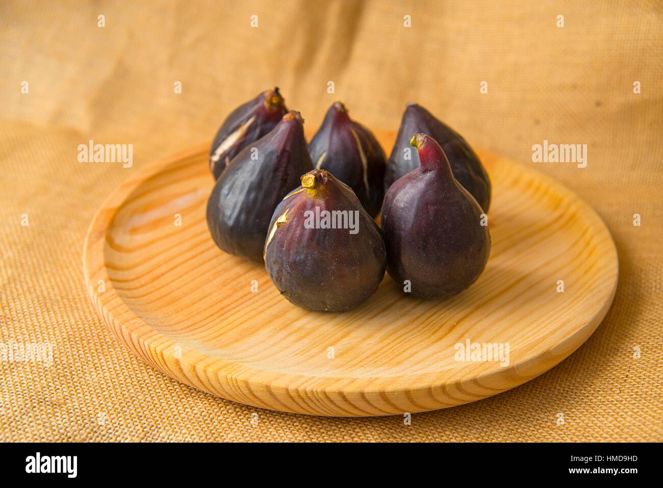 Six black figs on a wooden dish. Still life Stock Photo - Alamy