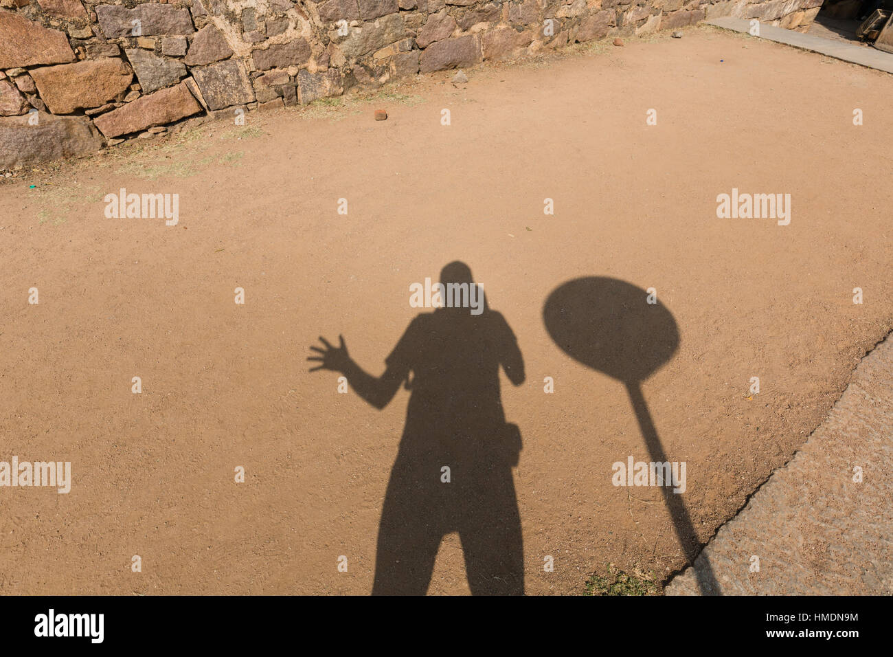 Shadow of a man taking a selfie standing next to a lamp post in ...