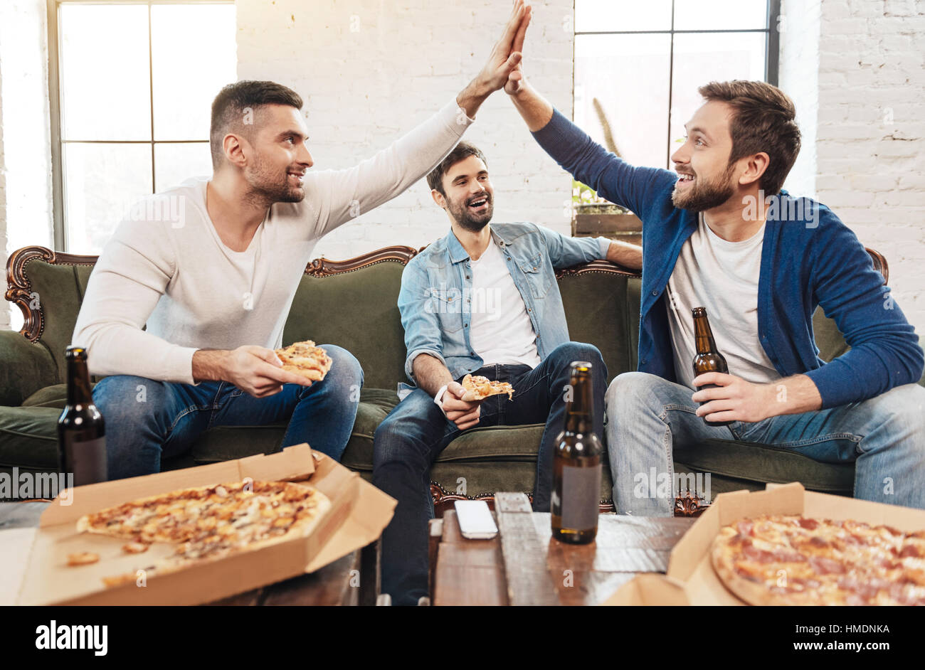 Handsome delighted men giving high five Stock Photo - Alamy