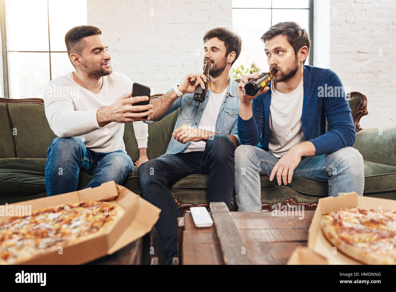 Handsome pleasant men taking a sip of beer Stock Photo - Alamy