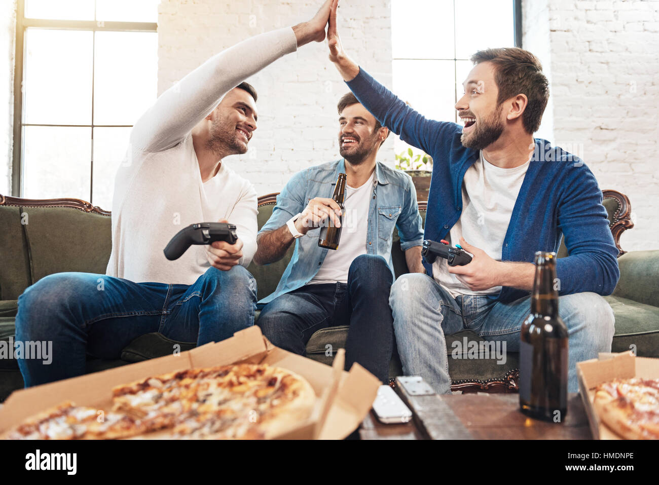 Positive male friends giving high five Stock Photo - Alamy
