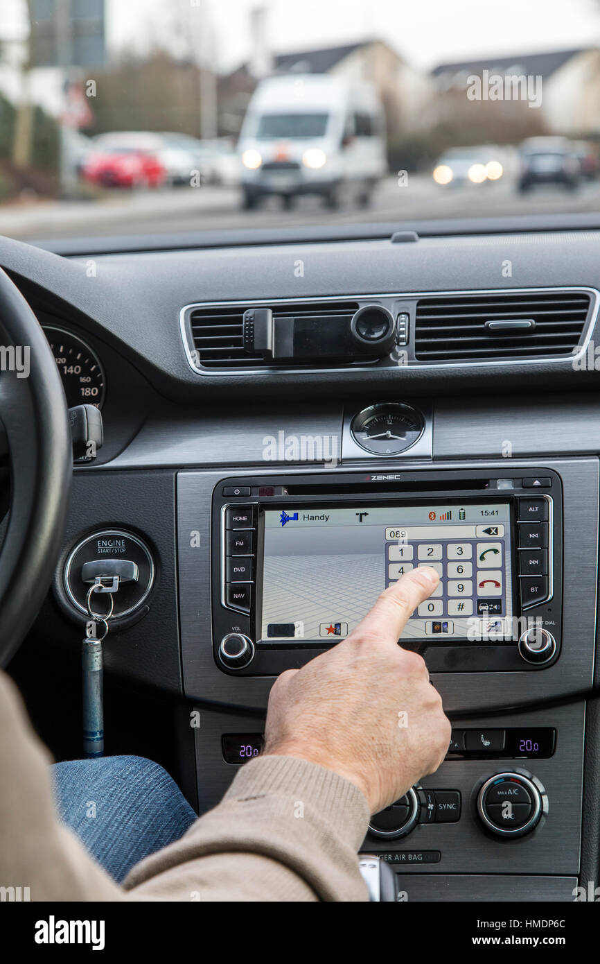 A car driver is using the cars navigation system, while driving the car ...