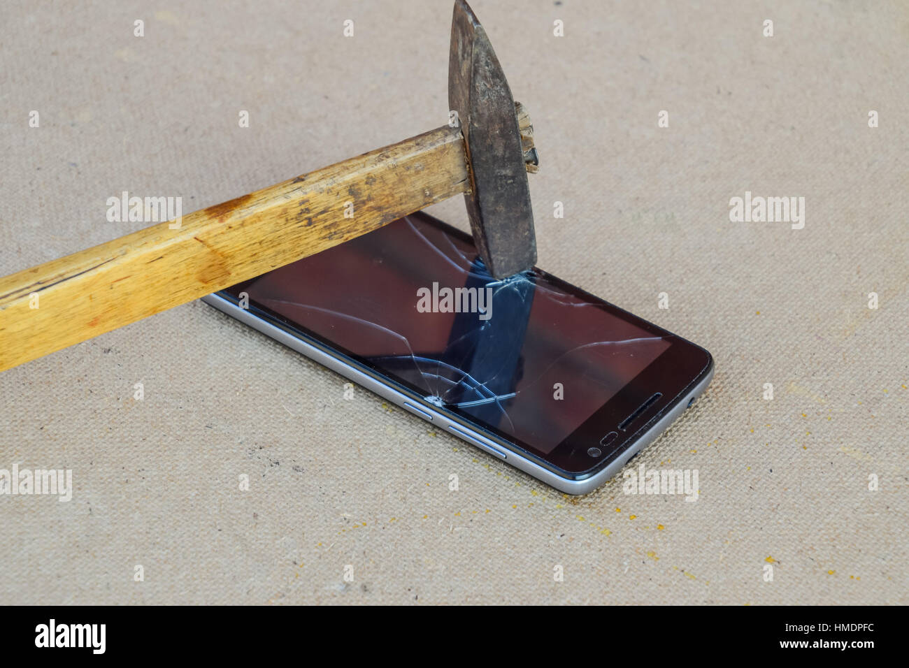 Hammer and smartphone. The screen of the smartphone, a broken hammer ...
