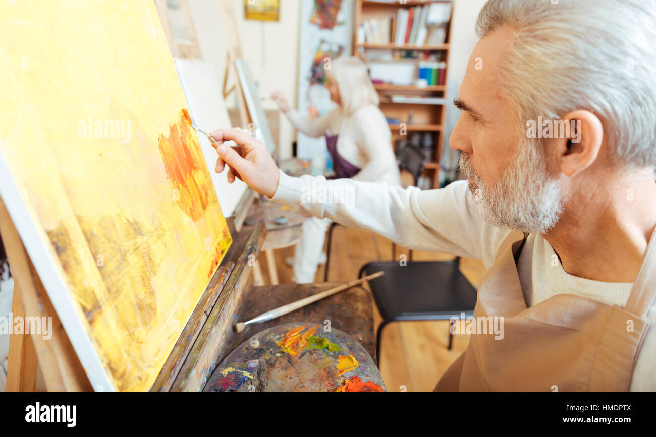 Concentrated artist painting a picture in class Stock Photo - Alamy