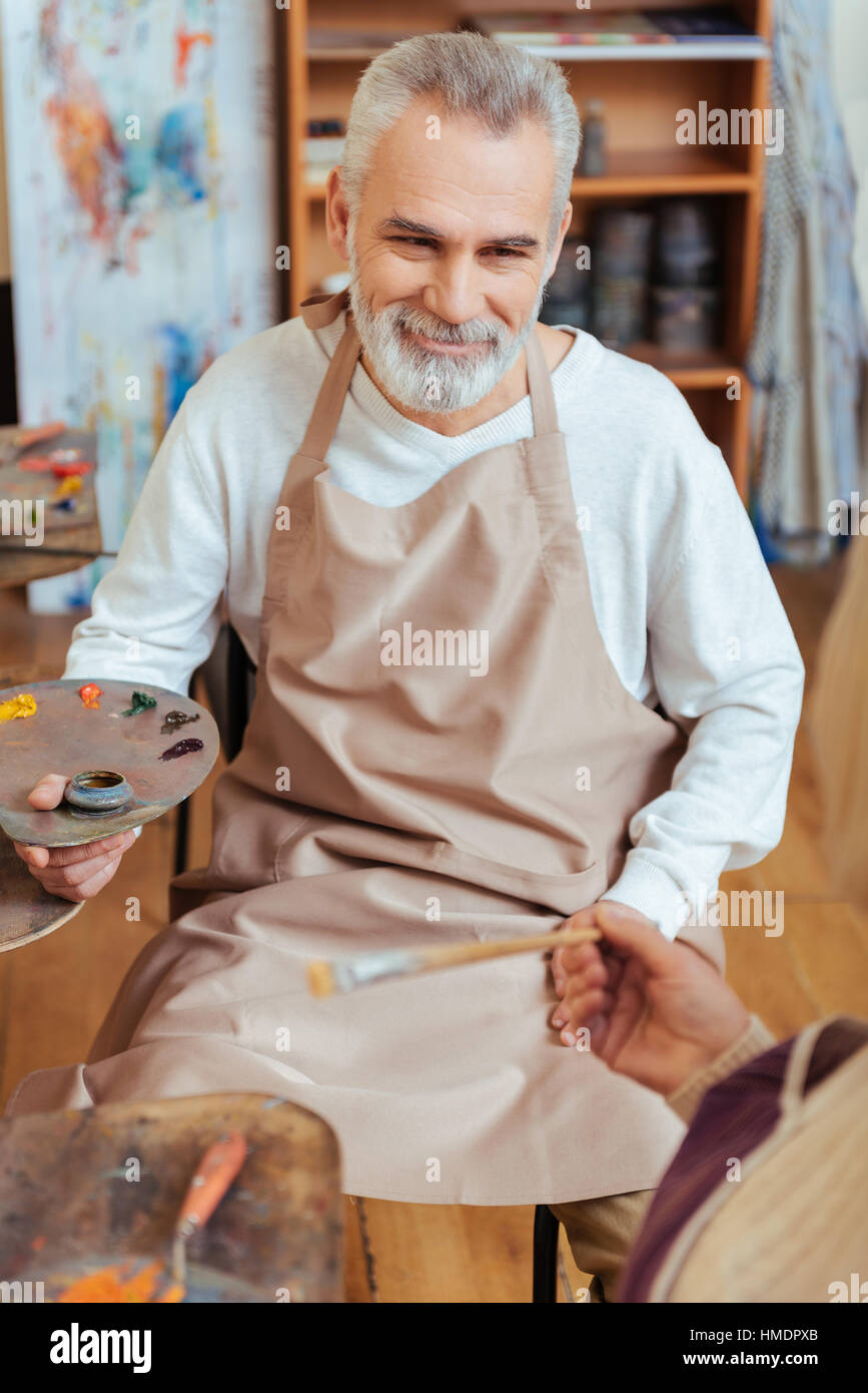 Happy artist wearing uniform in painting class Stock Photo - Alamy