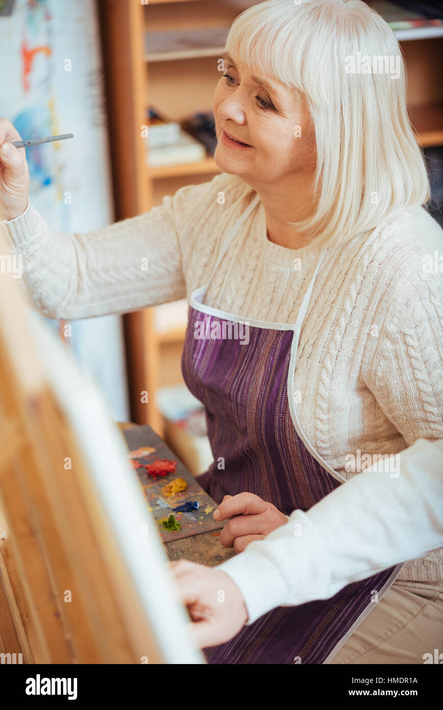 Delighted woman painting on a canvas Stock Photo - Alamy