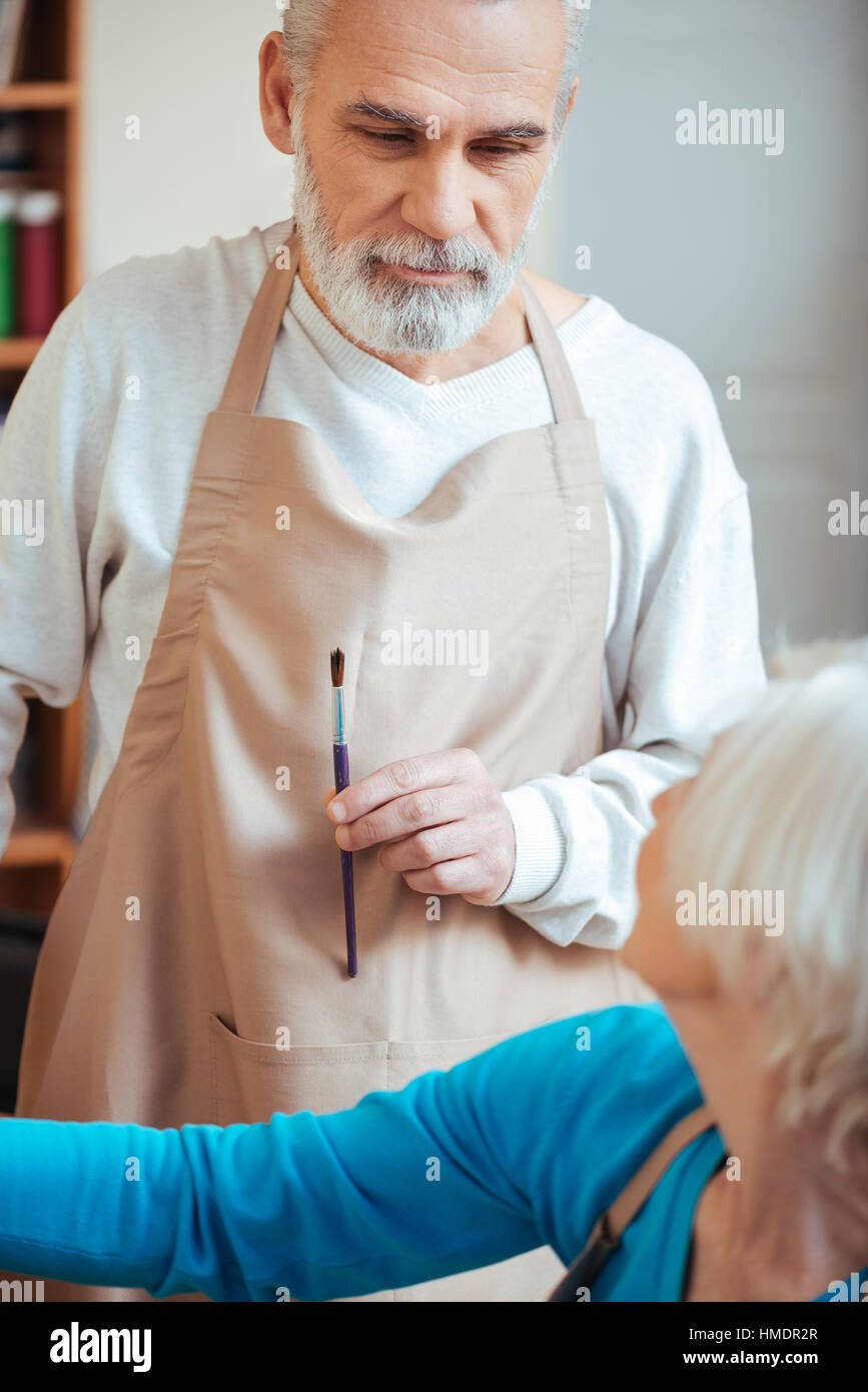 Concentrated artist giving advice to his female colleague Stock Photo ...