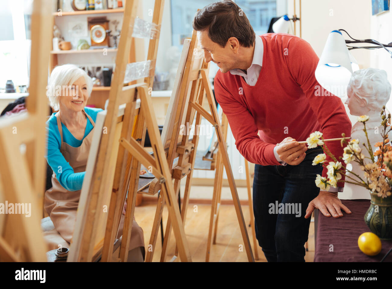 Happy artist pointing at flowers in painting studio Stock Photo - Alamy