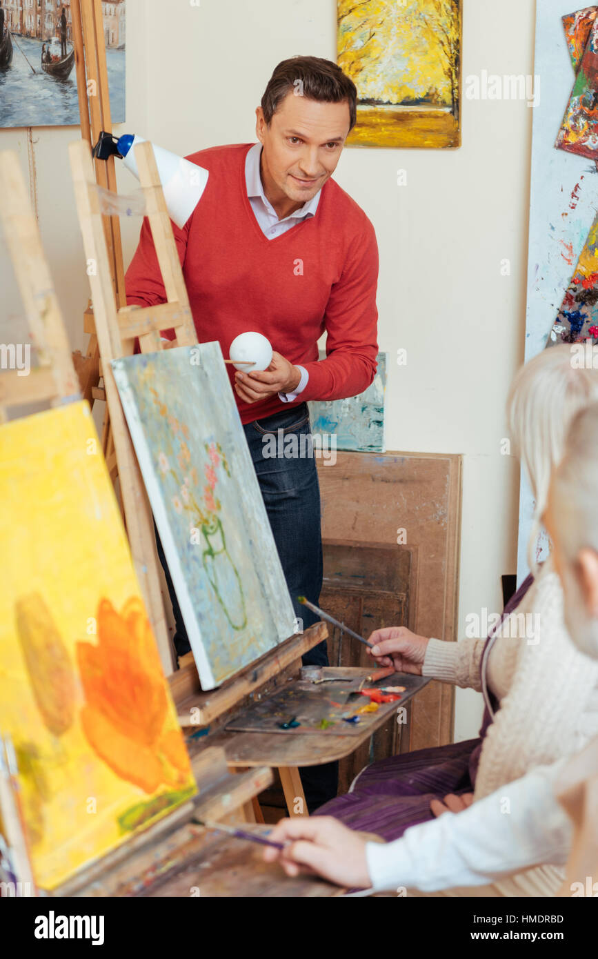 Overjoyed man teaching people in painting studio Stock Photo - Alamy