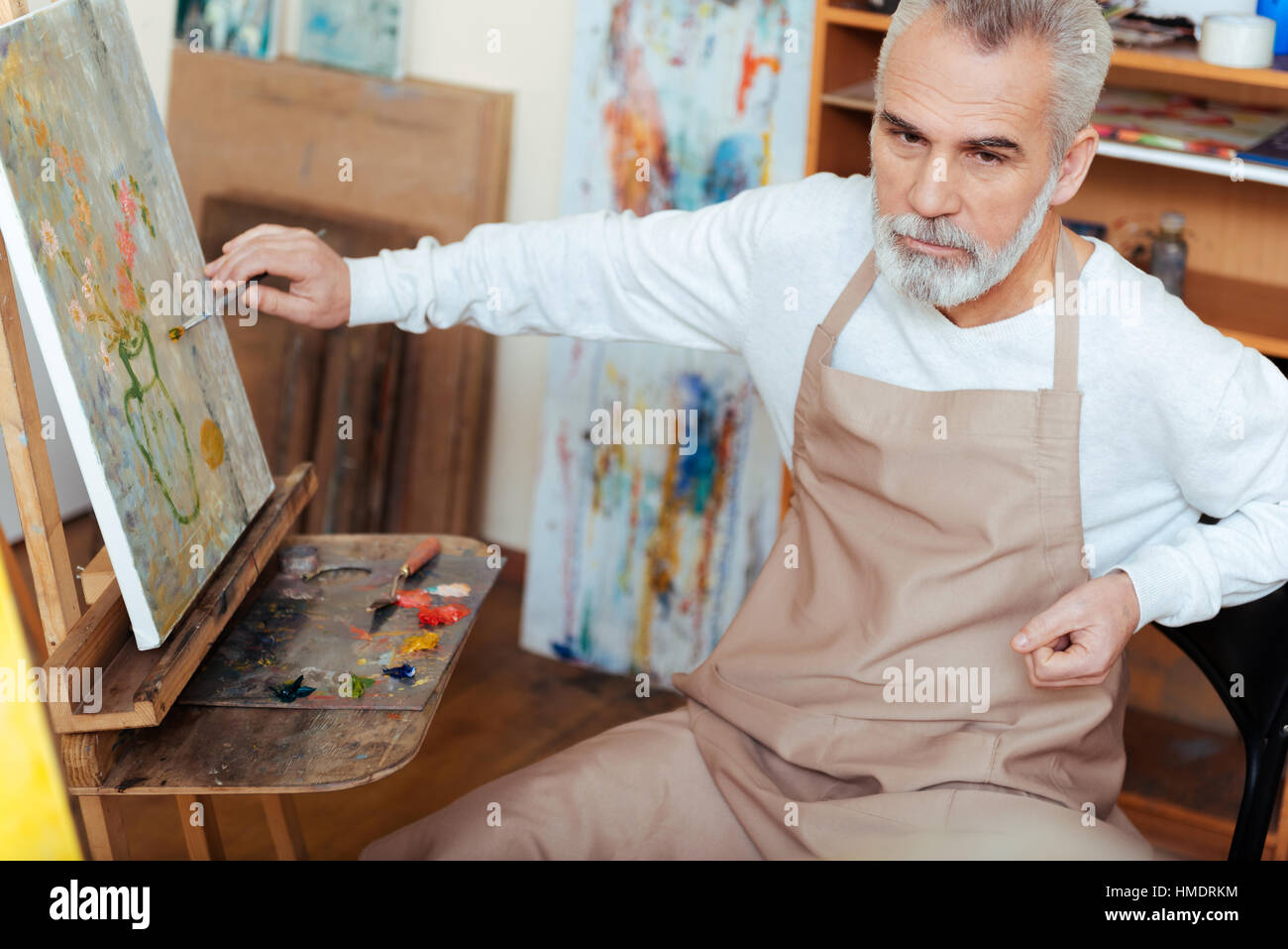 Concentrated artist painting a picture Stock Photo - Alamy