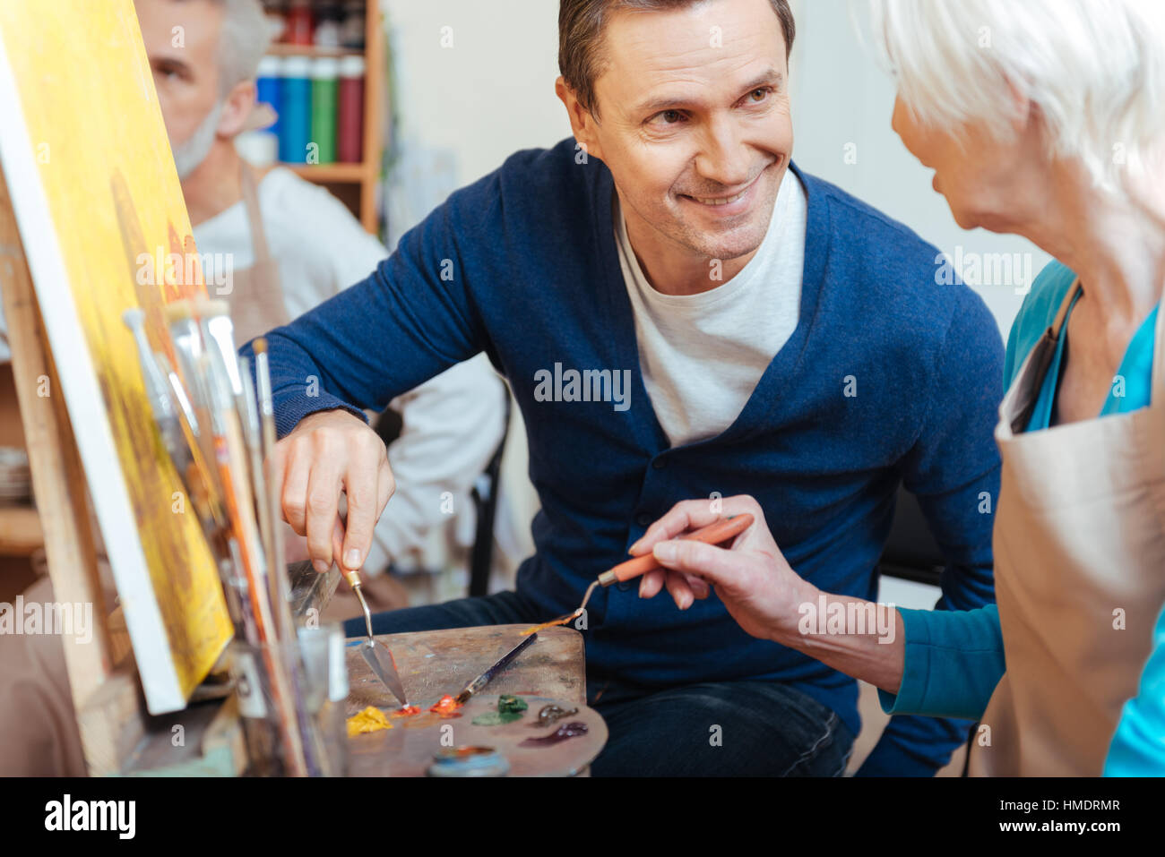 Friendly artist helping elderly woman in painting Stock Photo - Alamy