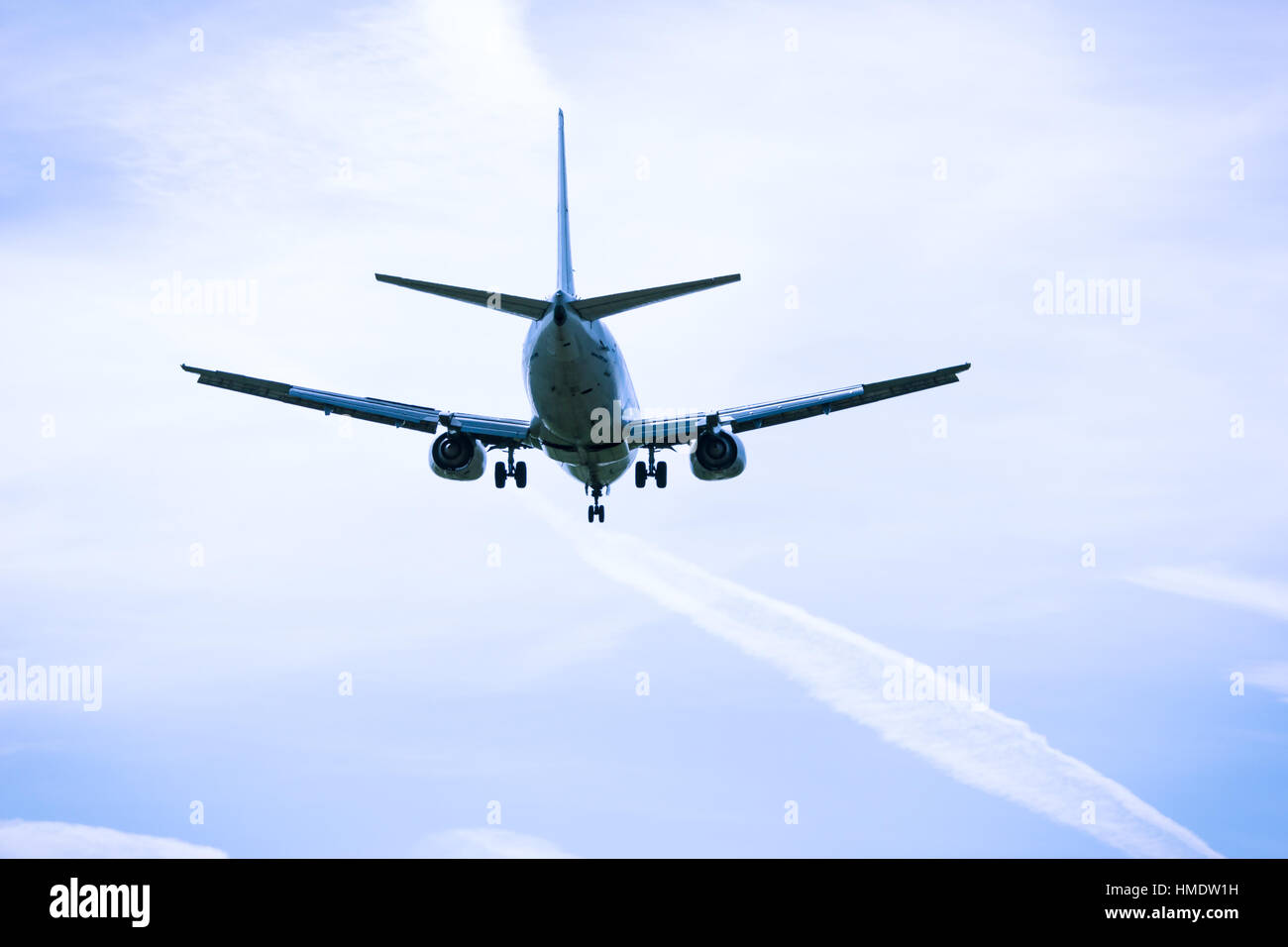Jet airplane flying overhead close-up on a blue sky background Stock ...