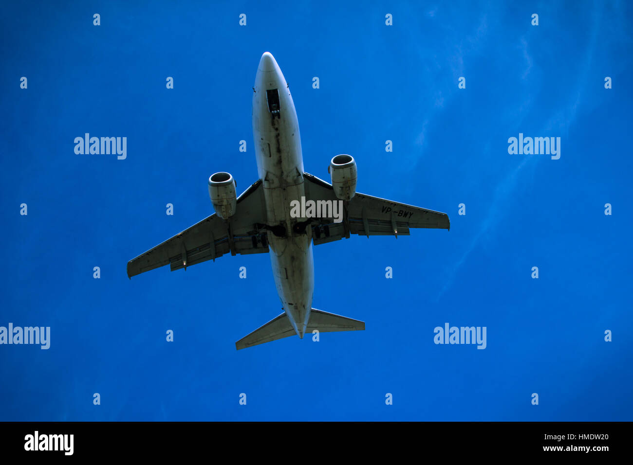 Jet airplane flying overhead close-up on a blue sky background Stock ...