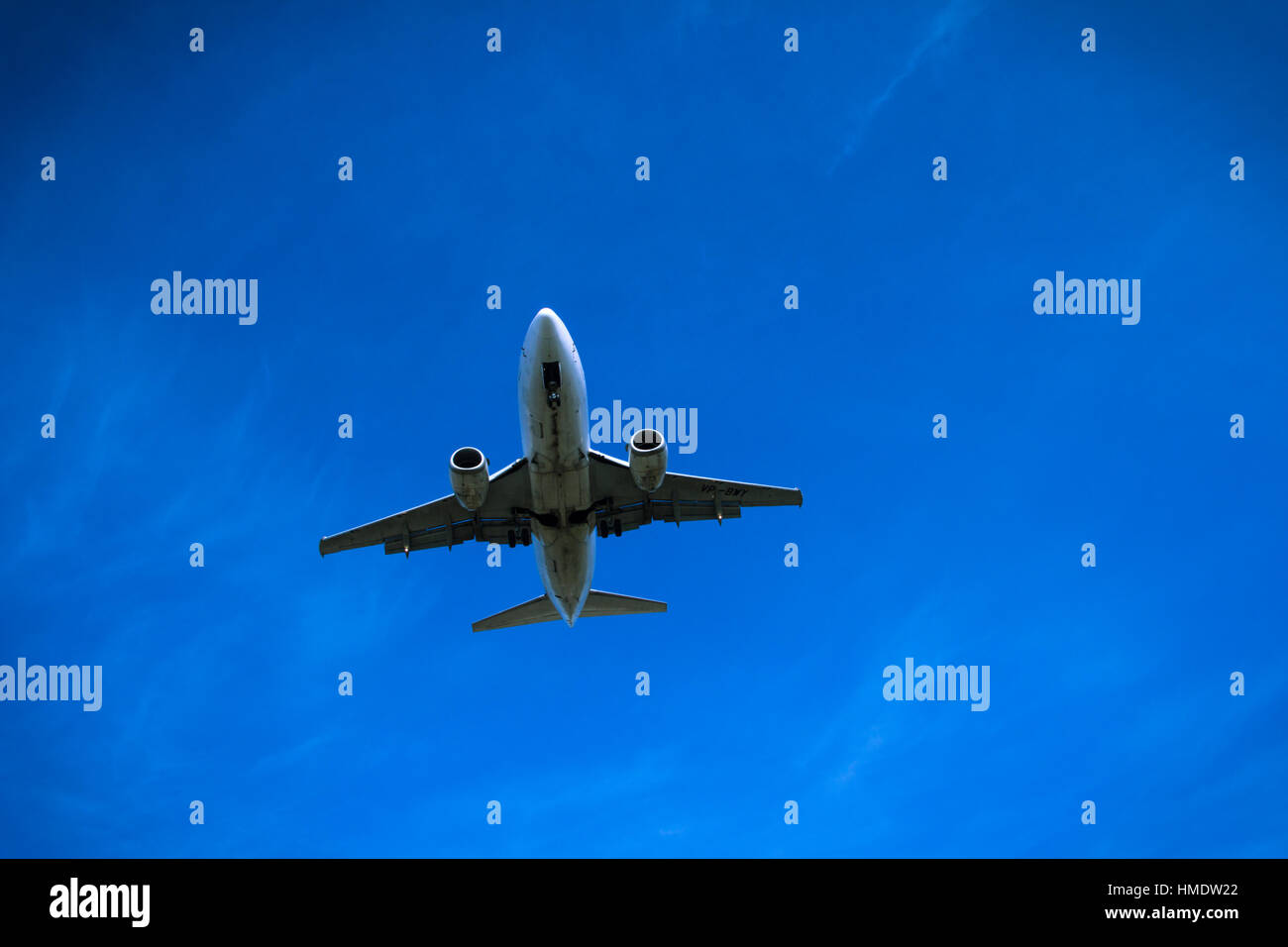 Jet airplane flying overhead close-up on a blue sky background Stock ...