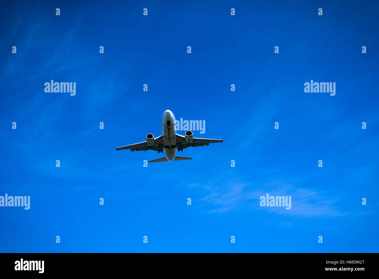 Jet airplane flying overhead close-up on a blue sky background Stock ...