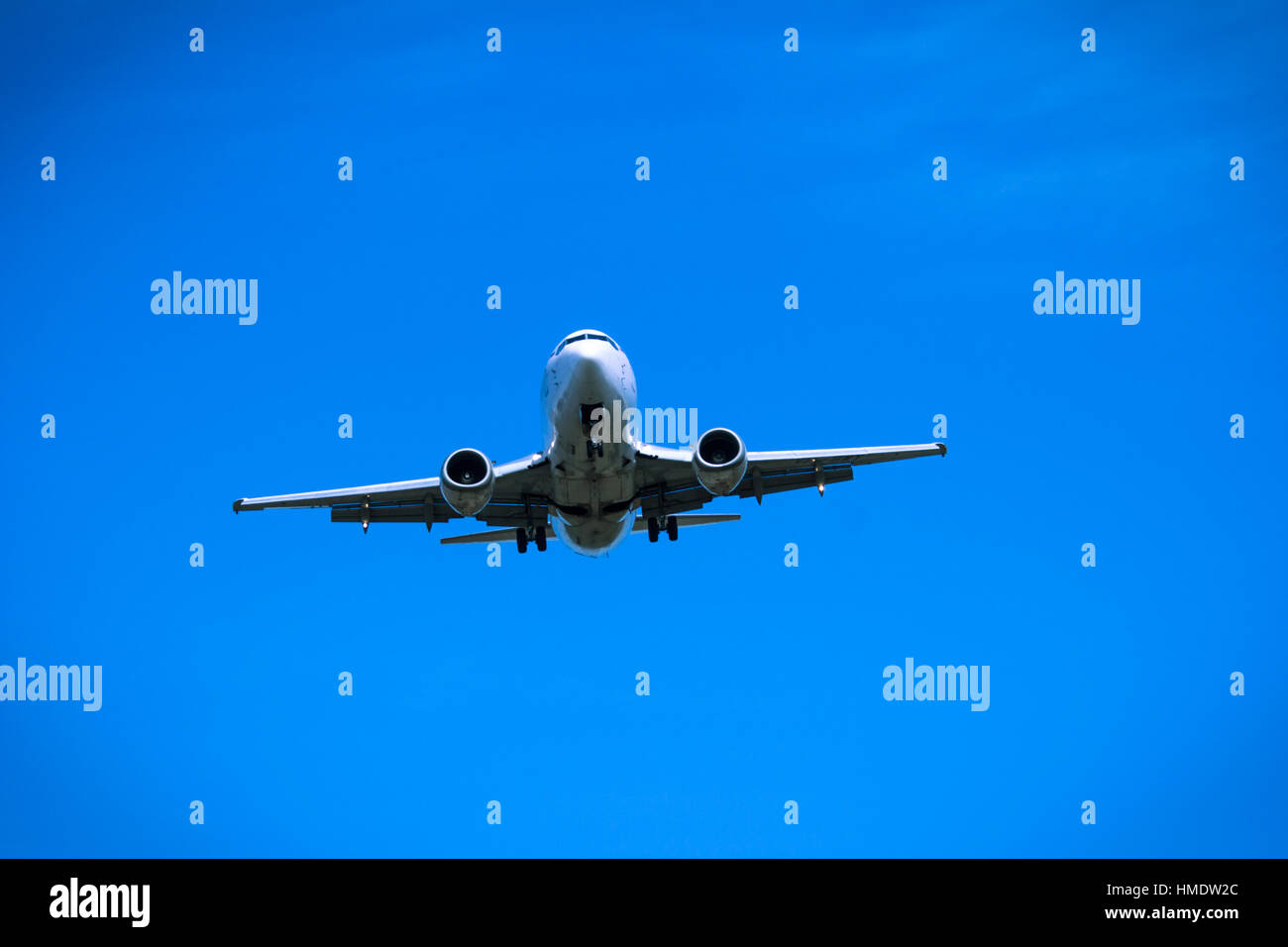 Jet airplane flying overhead close-up on a blue sky background Stock ...