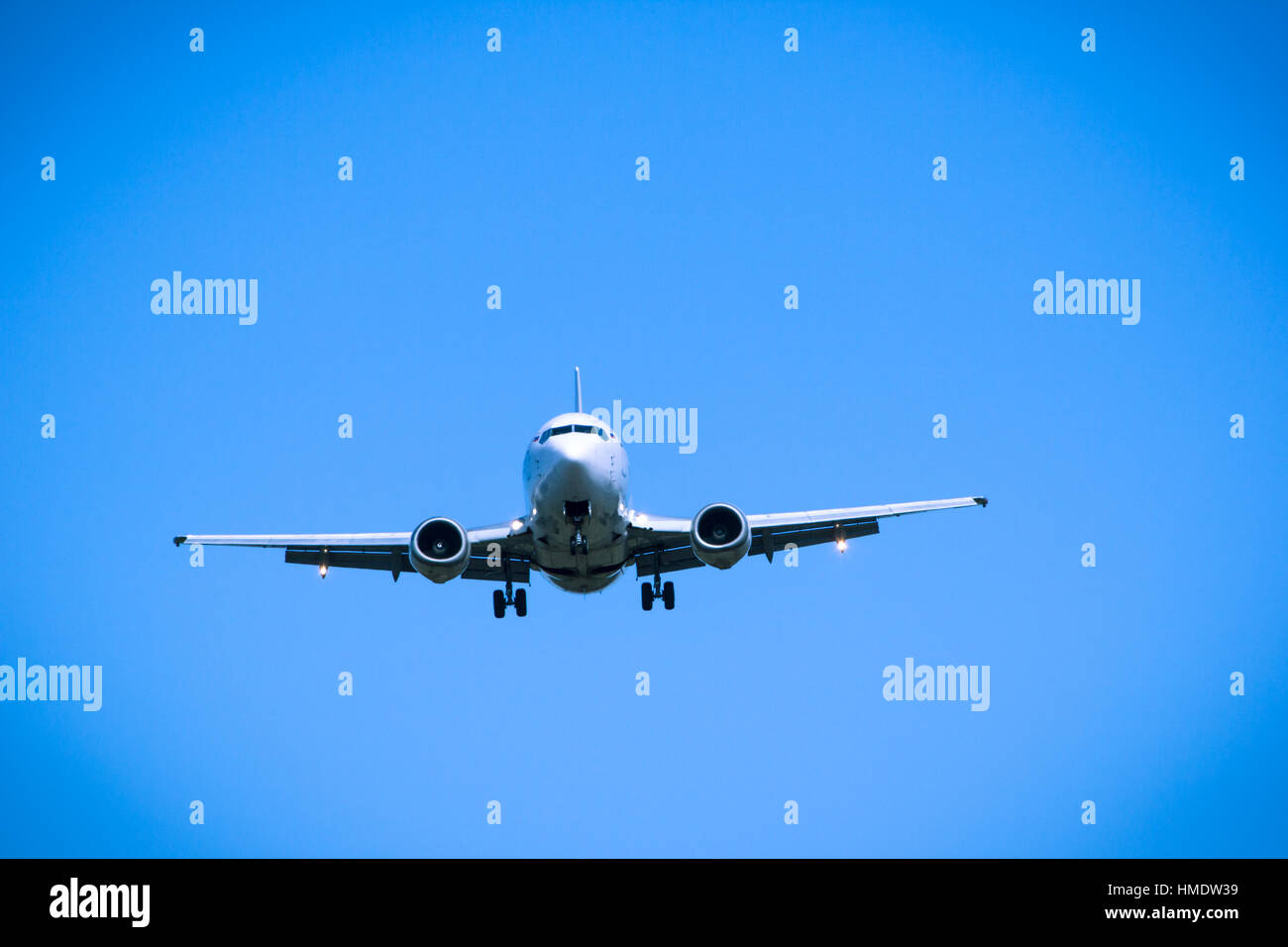 Jet airplane flying overhead close-up on a blue sky background Stock ...