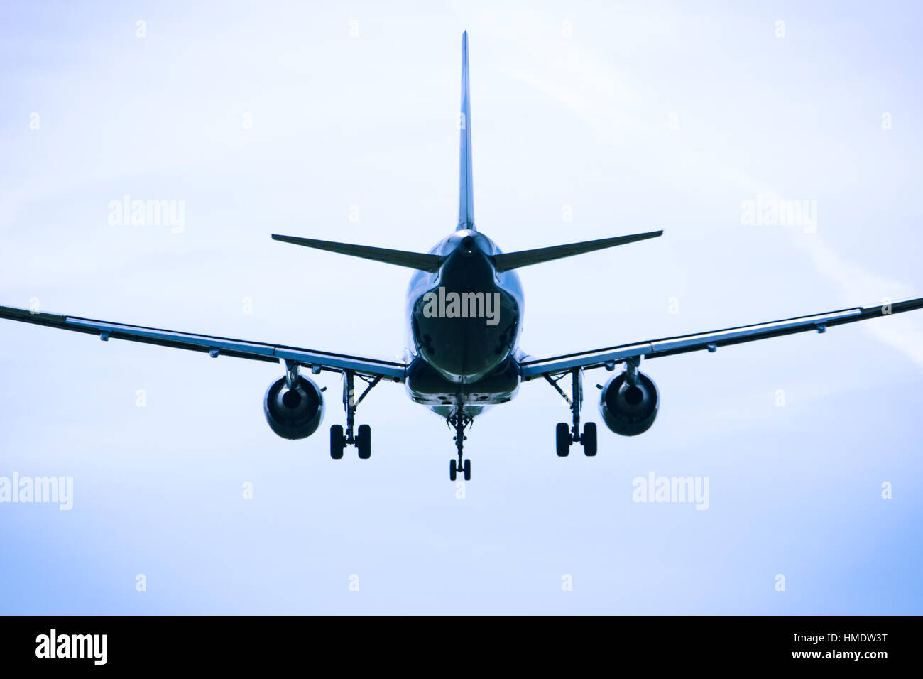 Jet airplane flying overhead close-up on a blue sky background Stock ...