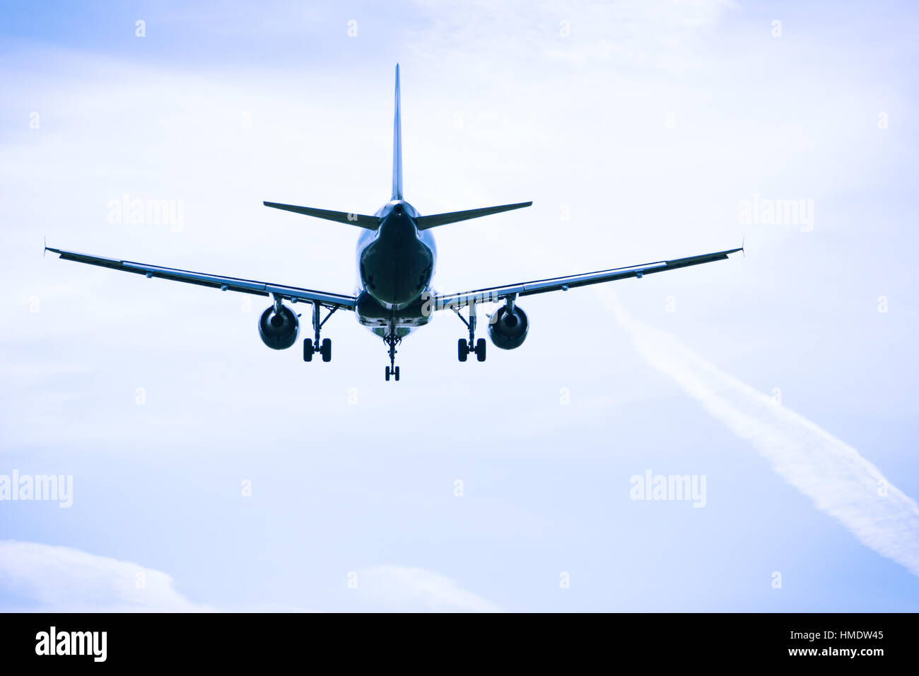 Jet airplane flying overhead close-up on a blue sky background Stock ...