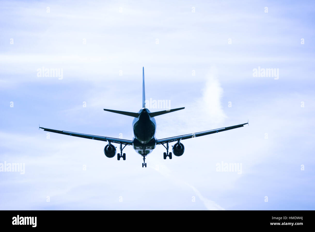 Jet airplane flying overhead close-up on a blue sky background Stock ...