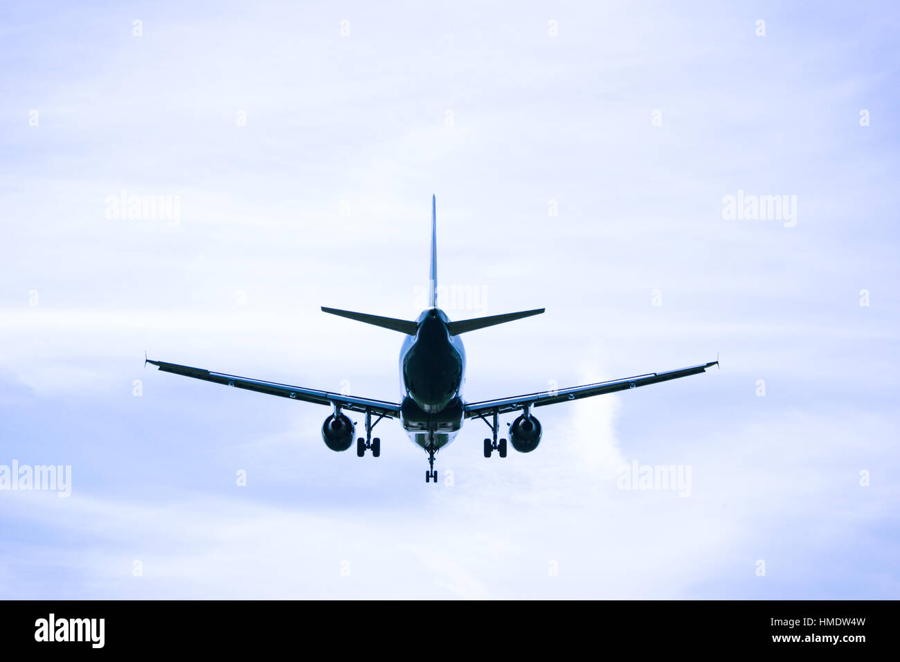 Jet airplane flying overhead close-up on a blue sky background Stock ...