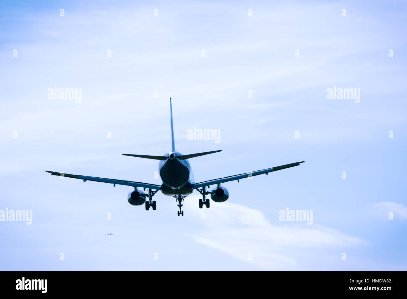 Jet airplane flying overhead close-up on a blue sky background Stock ...