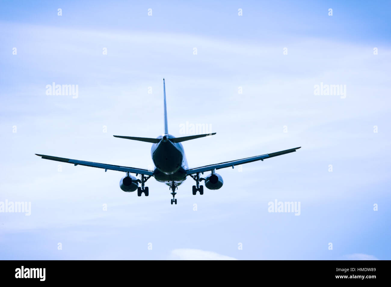 Jet airplane flying overhead close-up on a blue sky background Stock ...