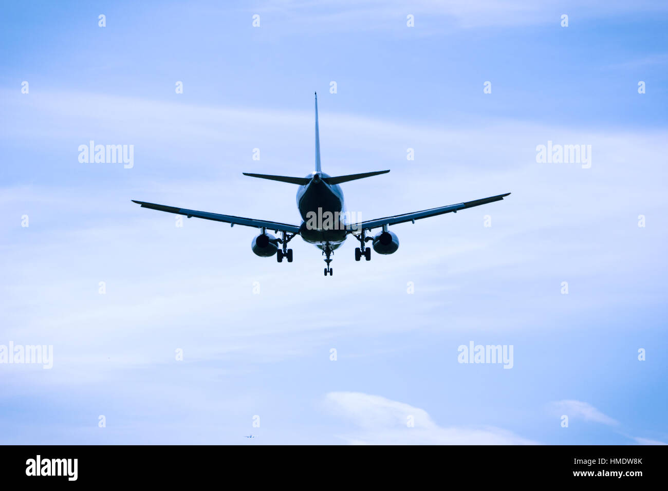 Jet airplane flying overhead close-up on a blue sky background Stock ...