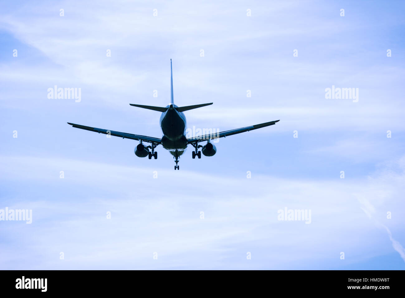 Jet airplane flying overhead close-up on a blue sky background Stock ...