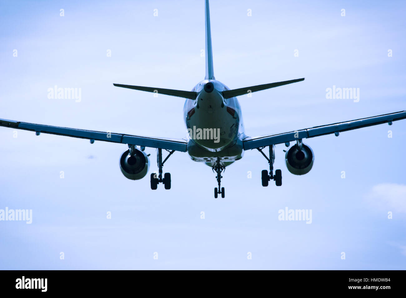 Jet airplane flying overhead close-up on a blue sky background Stock ...