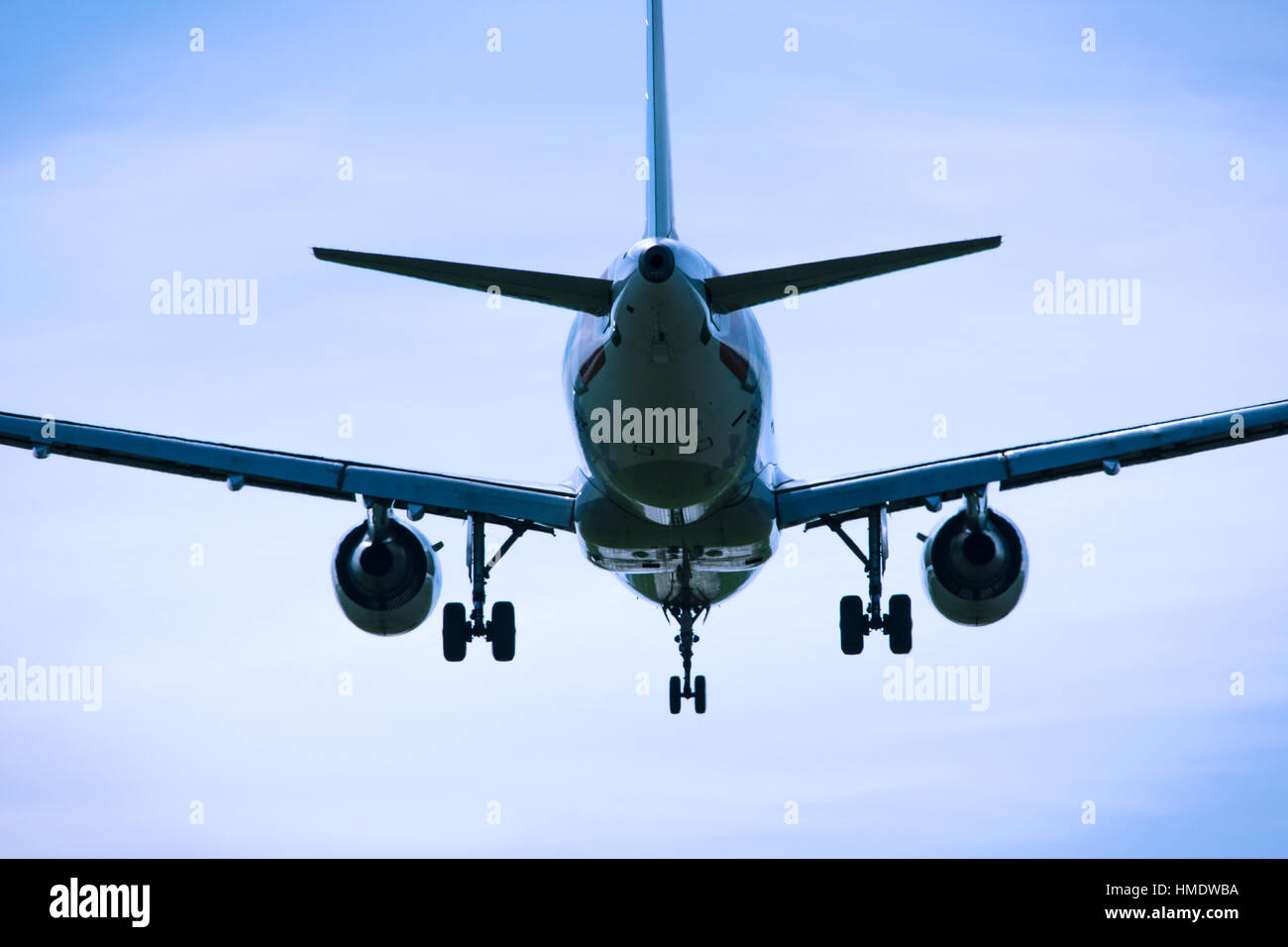 Jet airplane flying overhead close-up on a blue sky background Stock ...