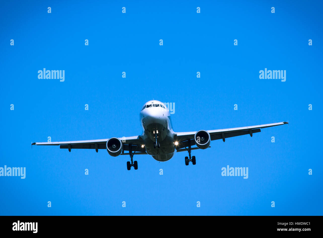 Jet airplane flying overhead close-up on a blue sky background Stock ...