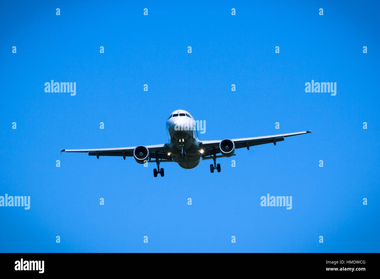 Jet airplane flying overhead close-up on a blue sky background Stock ...