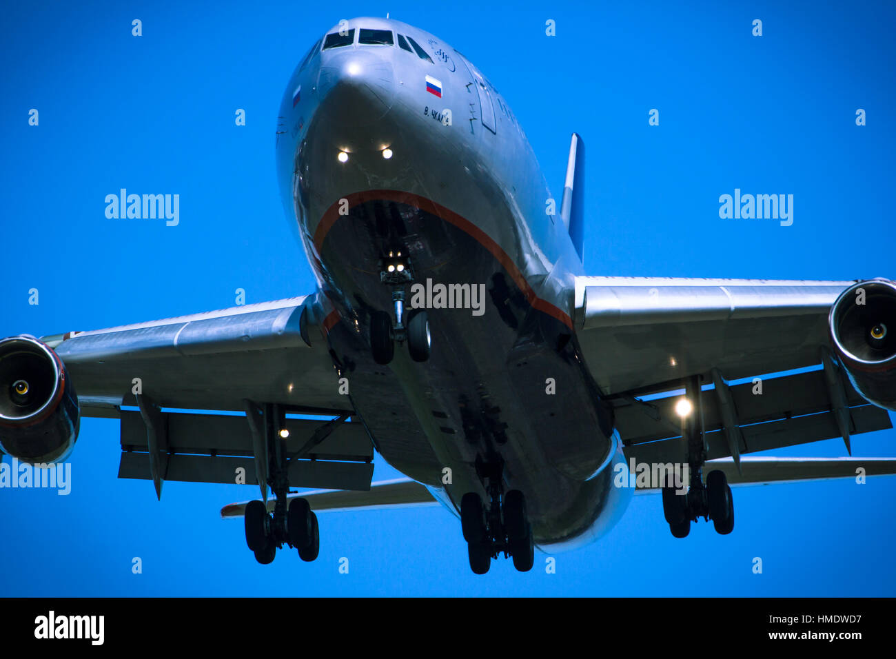 Jet airplane flying overhead close-up on a blue sky background Stock ...