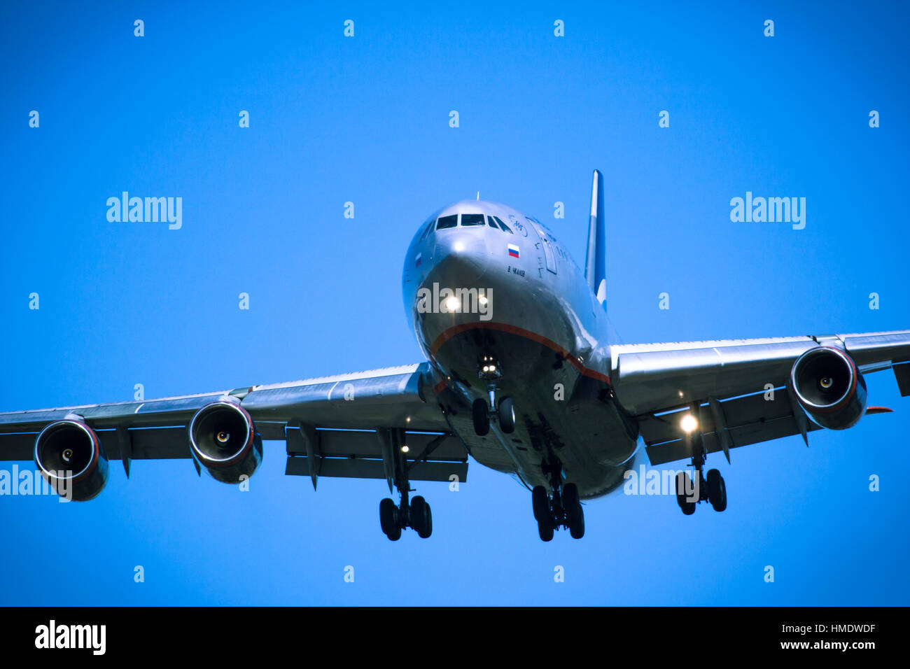 Jet airplane flying overhead close-up on a blue sky background Stock ...