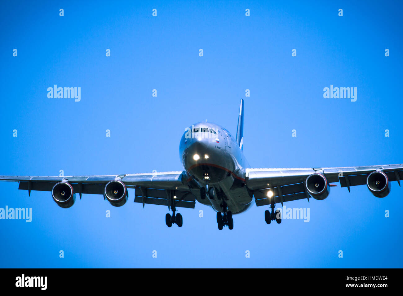 Jet airplane flying overhead close-up on a blue sky background Stock ...